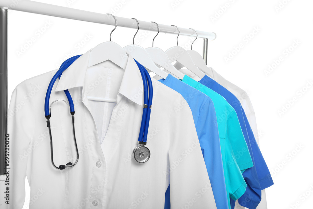 Doctor's gown with stethoscope and different medical uniforms on rack ...