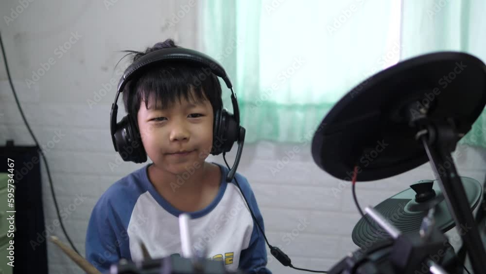 Asian child boy hold drumstick before playing electronic drum with ... Asian child boy hold drumstick before playing electronic drum with ...