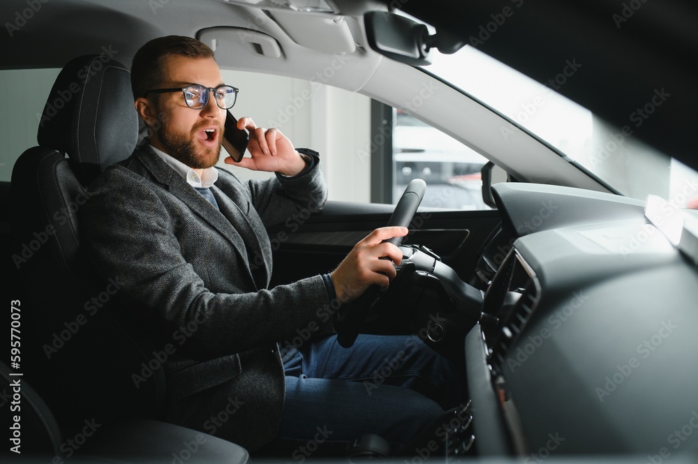 Handsome businessman driving car to airport, going on business side ...