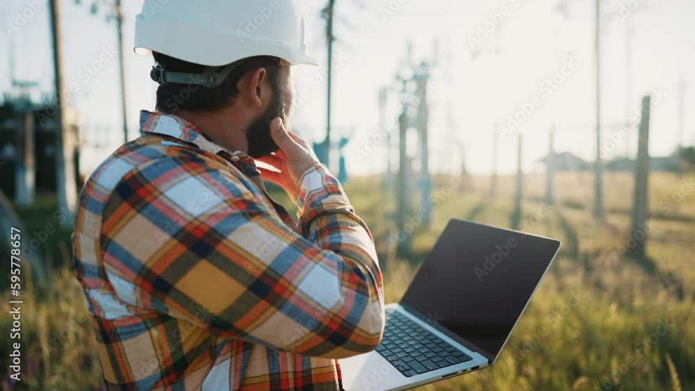 Engineer walk on field with electricity towers. Electrical engineer ...
