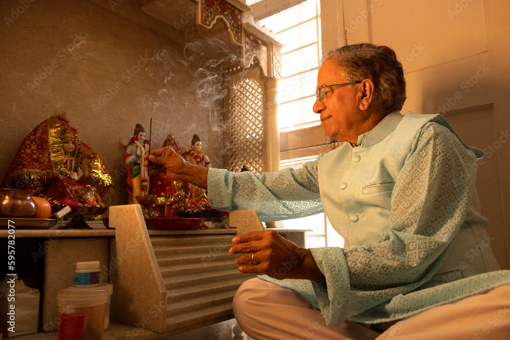 Portrait of senior man performing pooja of Hindu God at home Stock ...