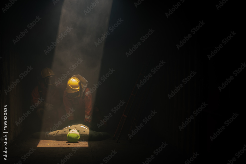 The two firefighters are carefully checking the pulse on the dummy ...