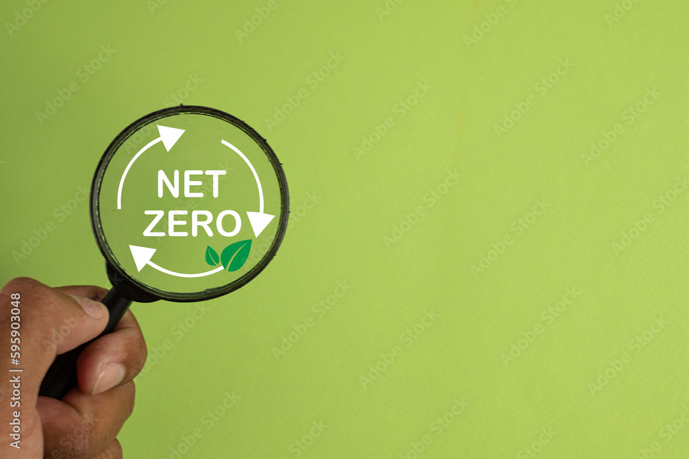 Net Zero emission concept.,Hand holding magnifying glass on left side photo focus on net zero ...