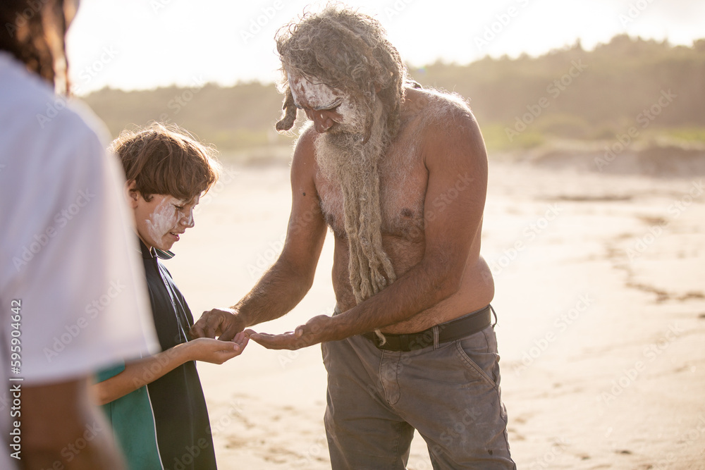 Aboriginal father helping son on a beach Stock Photo | Adobe Stock