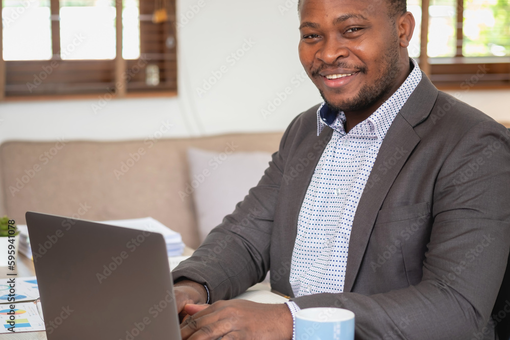 African American businessman analyzing laptop graph paperwork in office ...