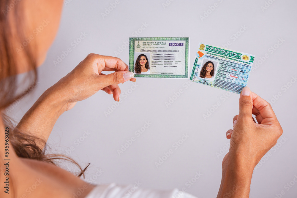Hands holding driver's license and identity card. Brazilian documents ...