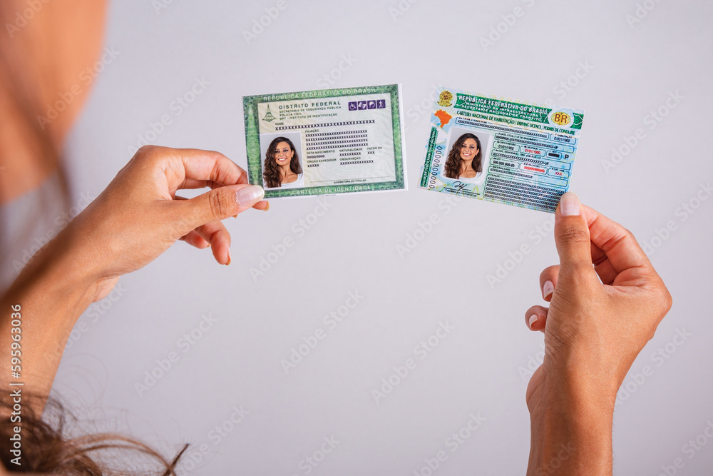 Hands holding driver's license and identity card. Brazilian documents ...