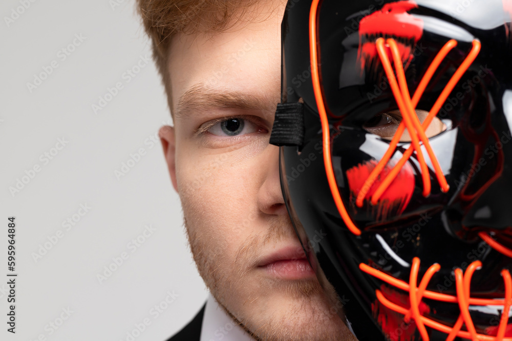 Stylish man in a sharp black formal suit covering half of his face with ...