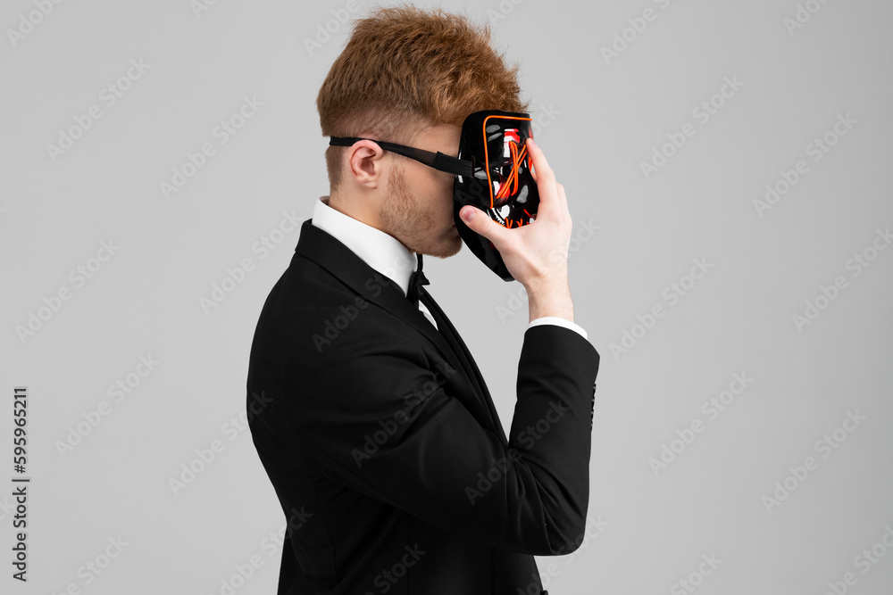 Stylish young man in a sharp black formal suit wearing a bright face ...