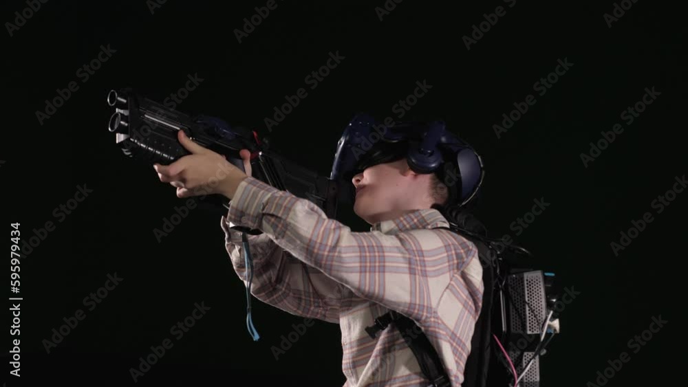 A boy in a VR headset with glasses, a backpack and a joystick-machine ...