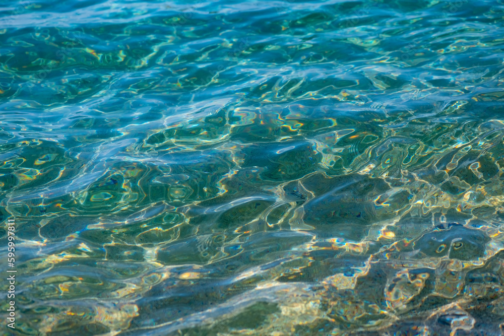 Sea water with colorful reflections of blue sky and white sandy ground ...