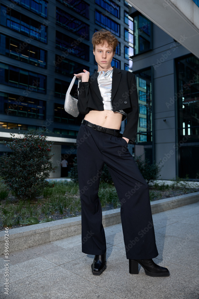 Full body vertical portrait of androgynous fashion model with red curly ...