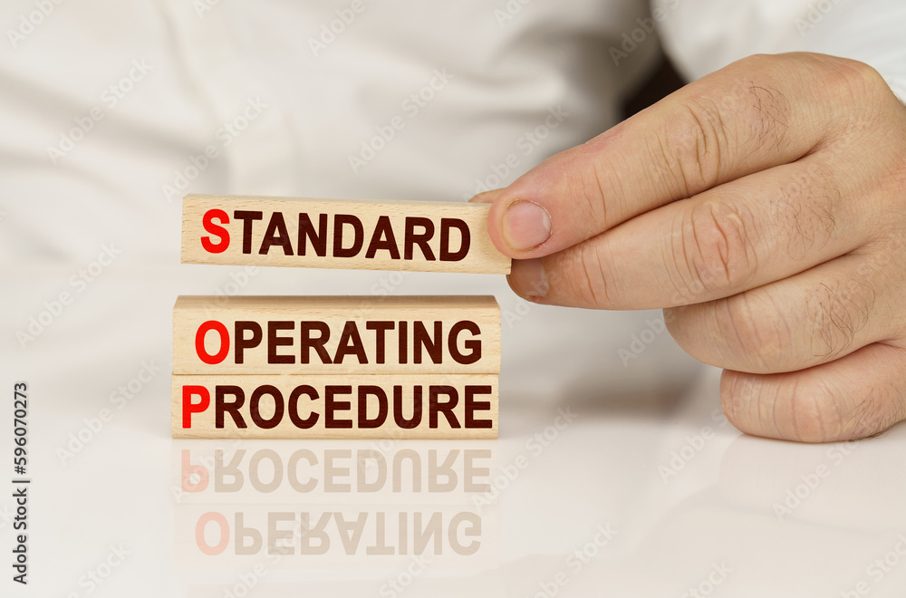 In the hands of a person and on a reflective surface are wooden blocks ...