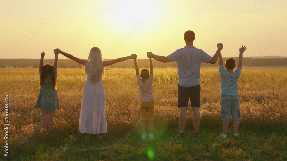 Happy family raise their hands outdoor at sunset. Teamwork of group of ...