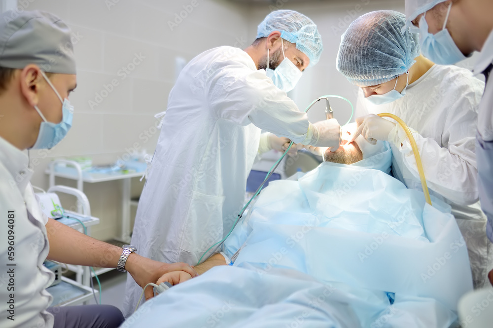 Foto de Surgeon and assistants during a dental operation.Anesthetized ...