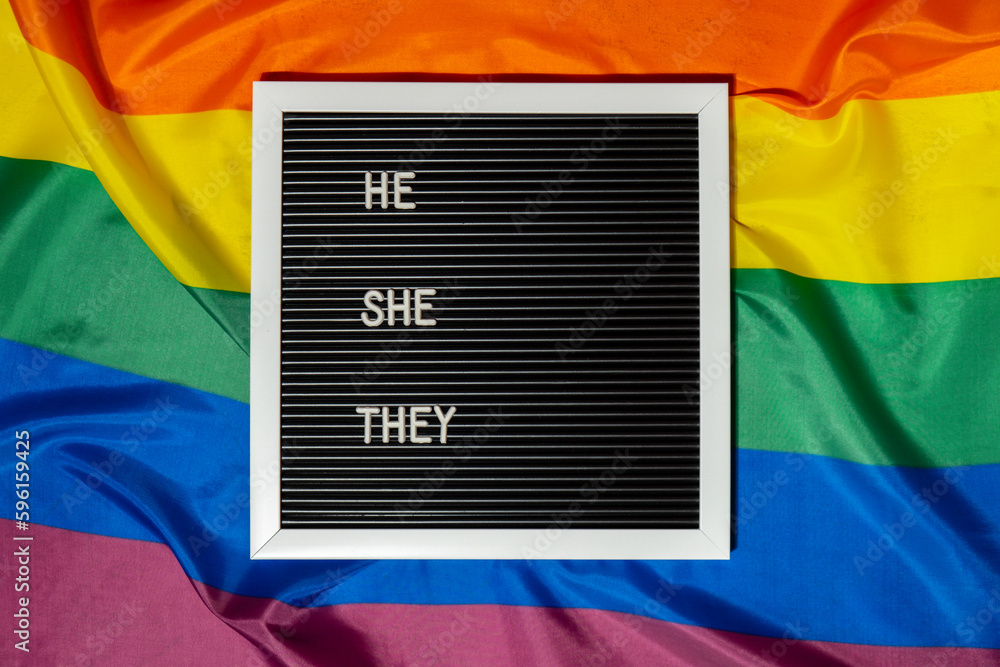 HE SHE THEY text Neo pronouns concept on Rainbow flag background gender ...
