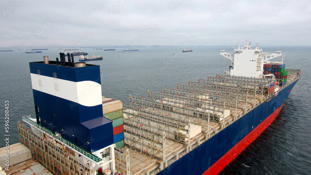 Aerial view of empty ultra large container ship at anchor near port ...