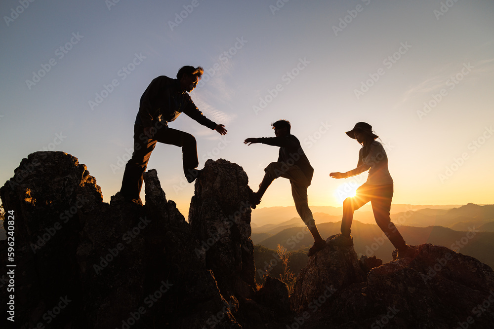 Silhouette of Hikers climbing up mountain cliff. Concept of help and ...