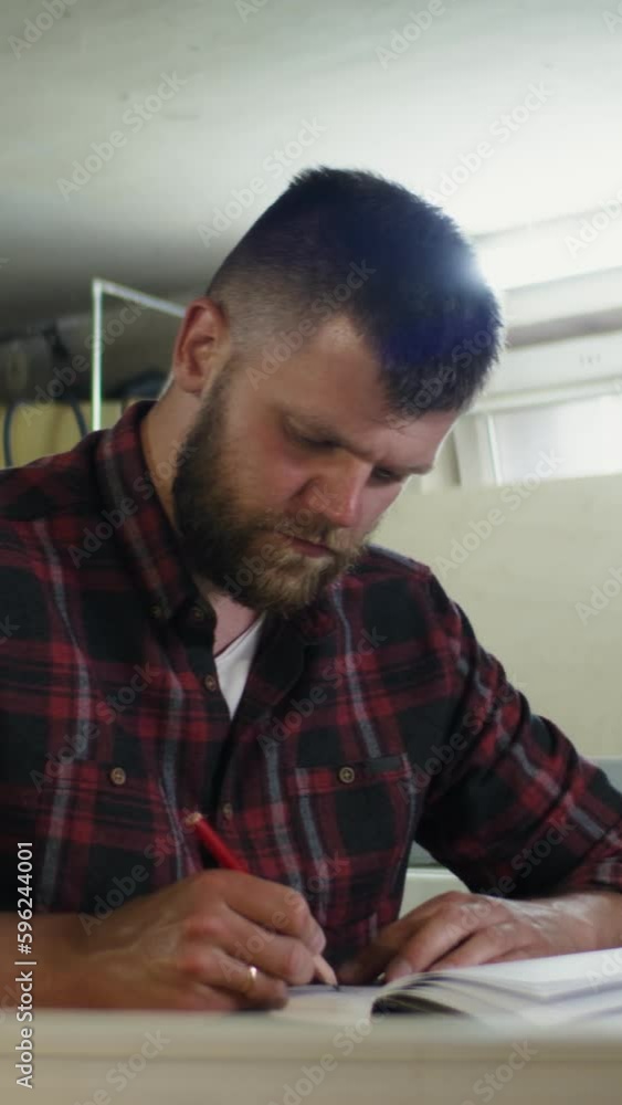 handsome serious man of European appearance with beard, in plaid shirt ...