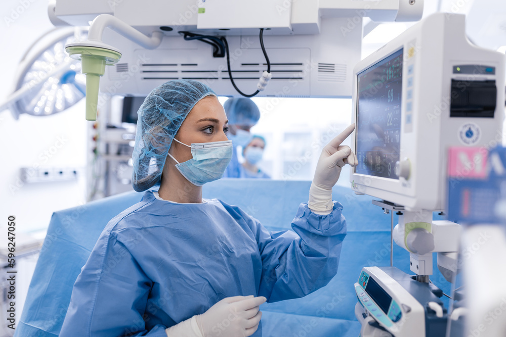 Anesthesiologist keeping track of vital functions of the body during ...
