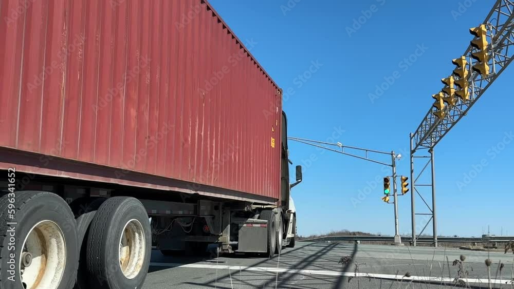 Truck with a semi-trailer makes traffic at an intersection with traffic lights. Semi-trailer ...