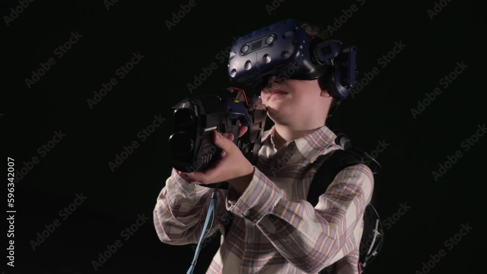 A teenage child using a VR headset helmet and an automatic controller ...