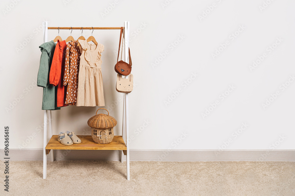 Fashion dresses in vintage colors on hangers in wardrobe. Wooden ...