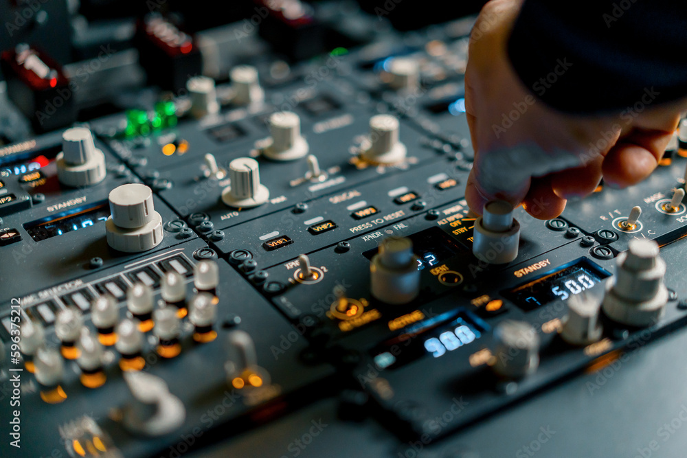 The captain presses the buttons on the control panel to start the ...