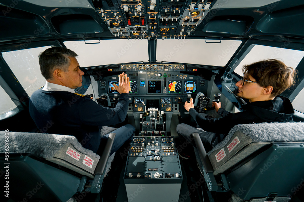 An experienced pilot instructs a young student before a training flight ...