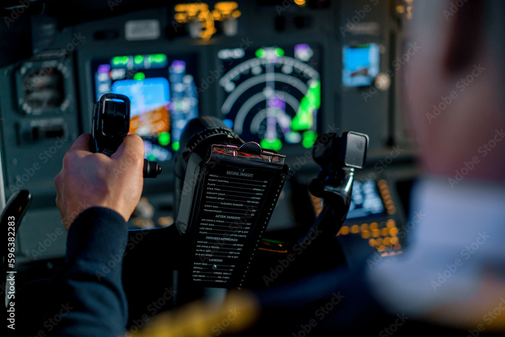 Pilot in airplane cockpit holding turning wheel rudder during flight ...