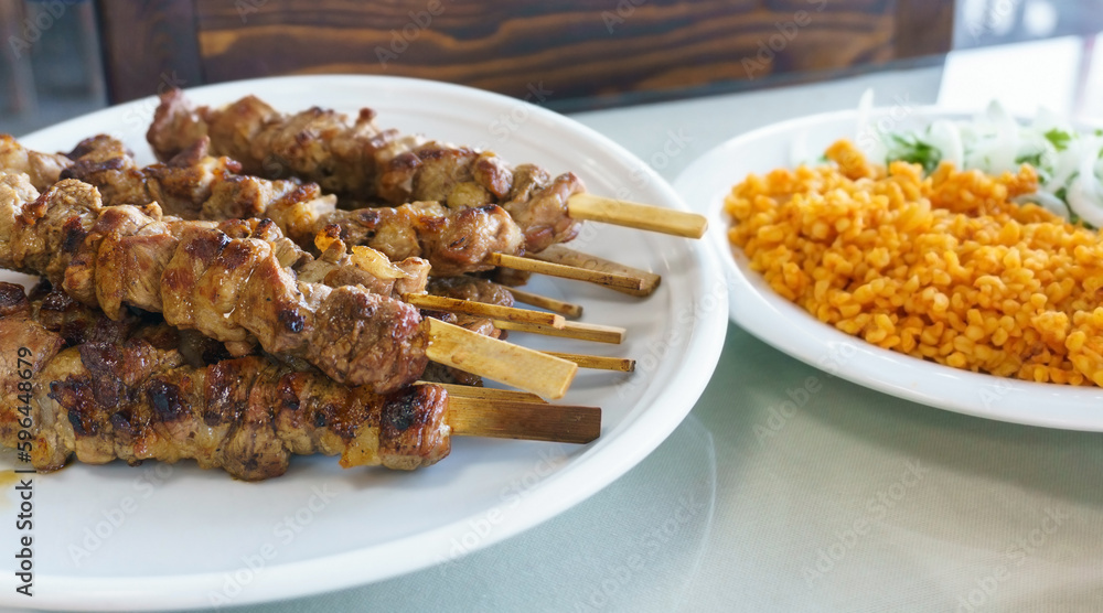 Turkish shish kebabs with bulgur pilaf with tomato paste on table ...