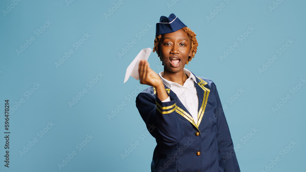Female model showing folded airplane in studio, playing with paper ...