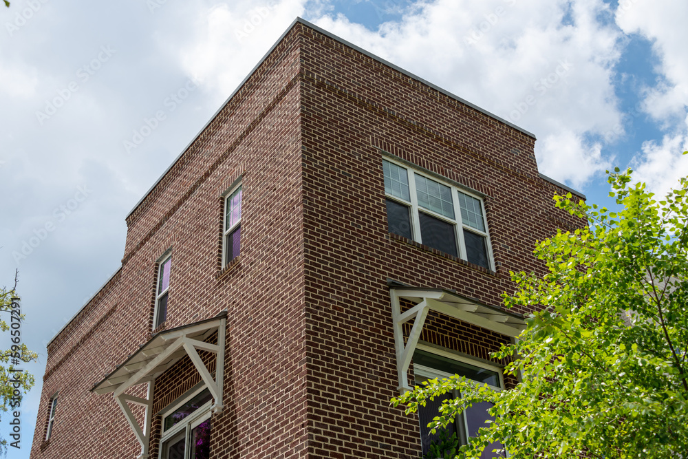 The exterior of a tall brown colored brick building with multiple ...