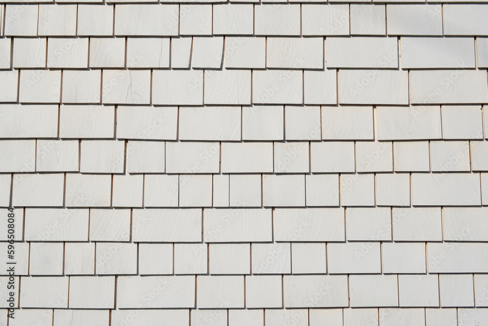 The exterior wall of a white residential building with cedar shake ...