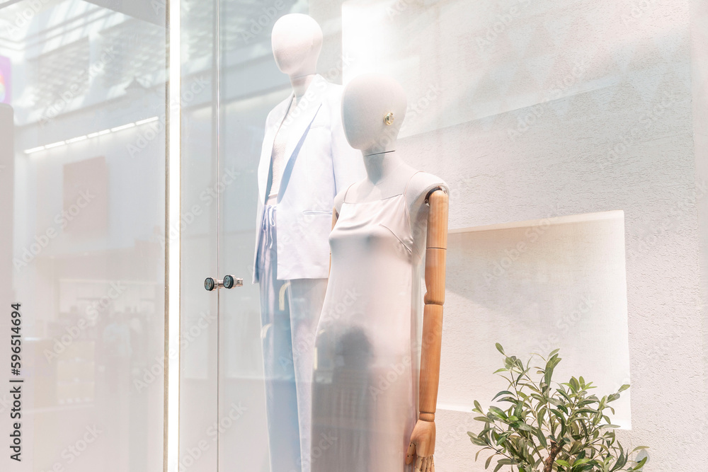 Female mannequins in elegant summer clothes in pastel colors in a ...