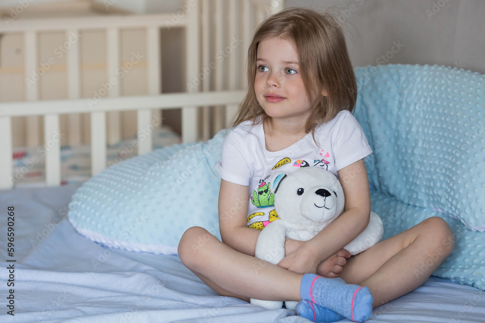 Family, childhood and love. Portrait of a beautiful little girl in bed ...