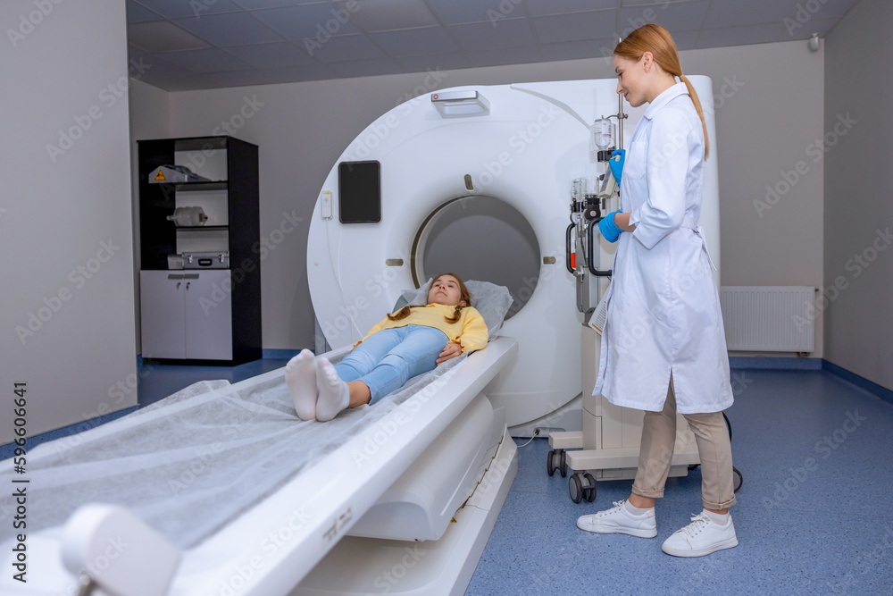 Little patient lying on long medical table during MRI scan procedure in ...