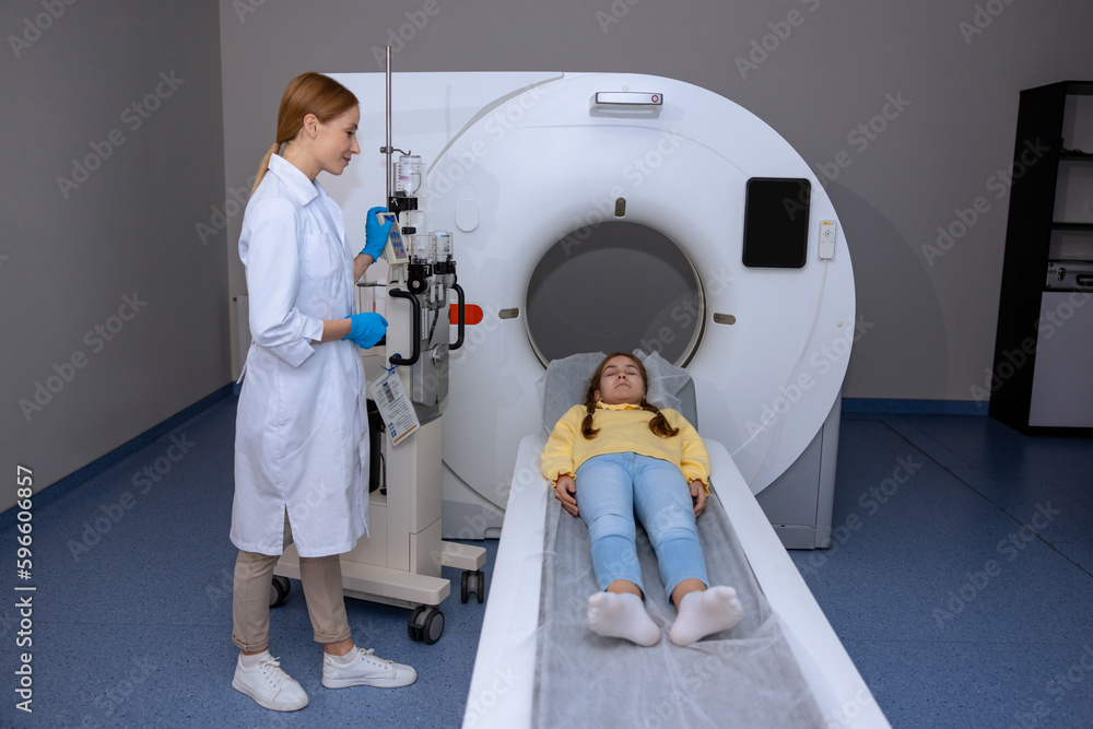 Little patient lying on long medical table during MRI scan procedure in ...
