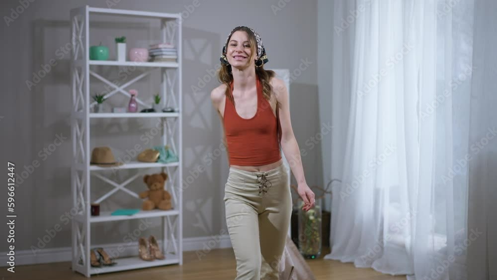 Beautiful woman taking off coat smiling looking at camera turning ...