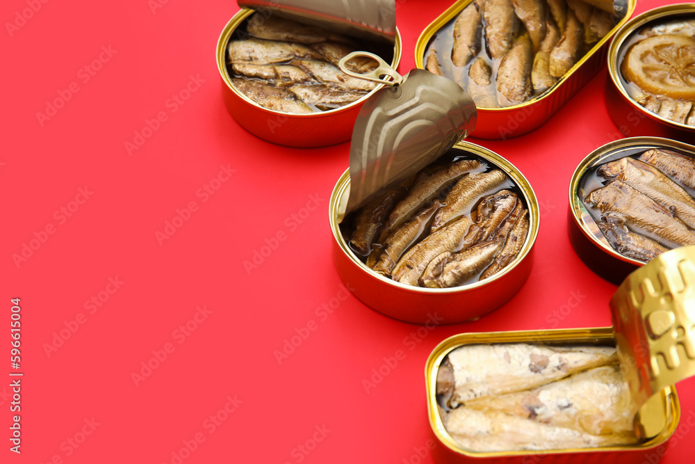 Opened tin cans with different fish on red background Stock Photo ...