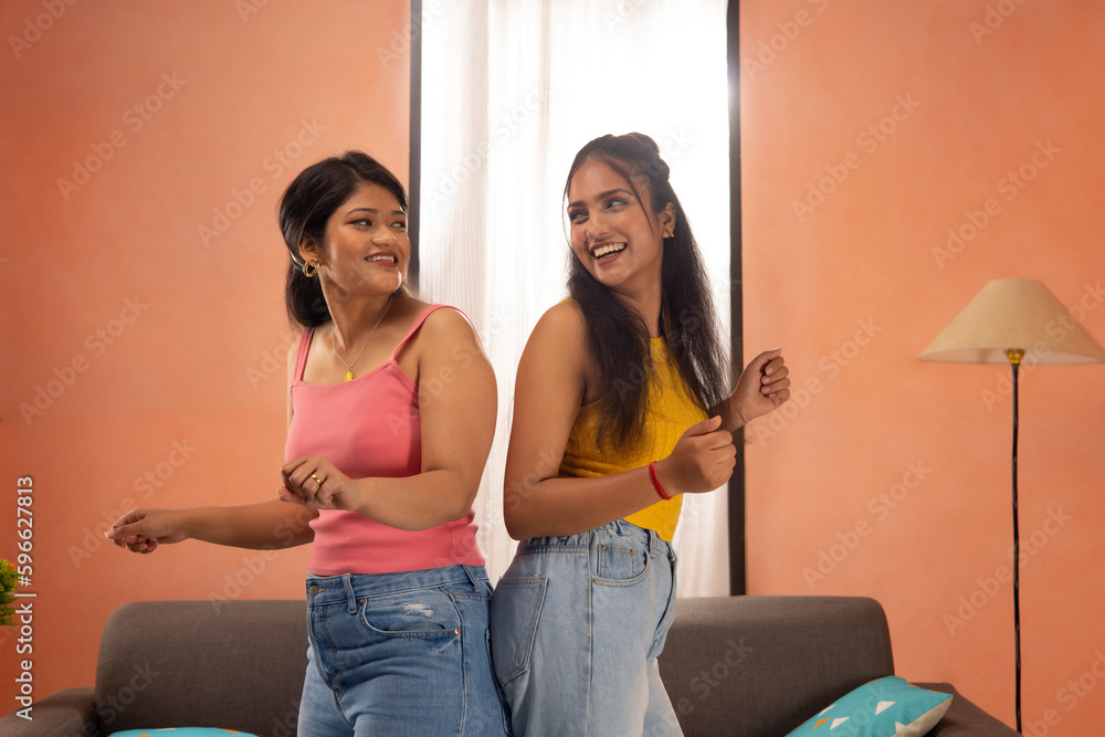 Two young women dancing together in living room Stock Photo | Adobe Stock