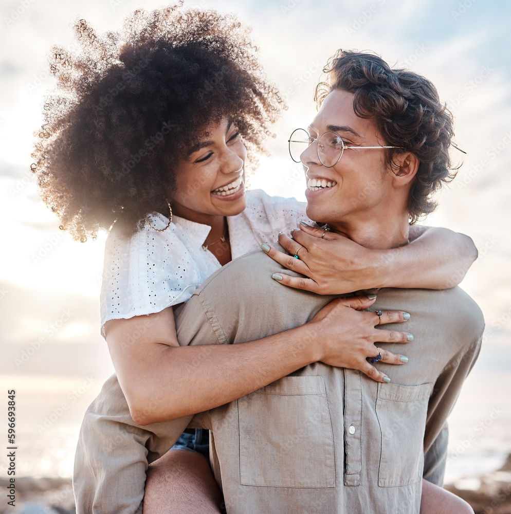 A young mixed race couple enjoying a day at the beach looking happy and ...