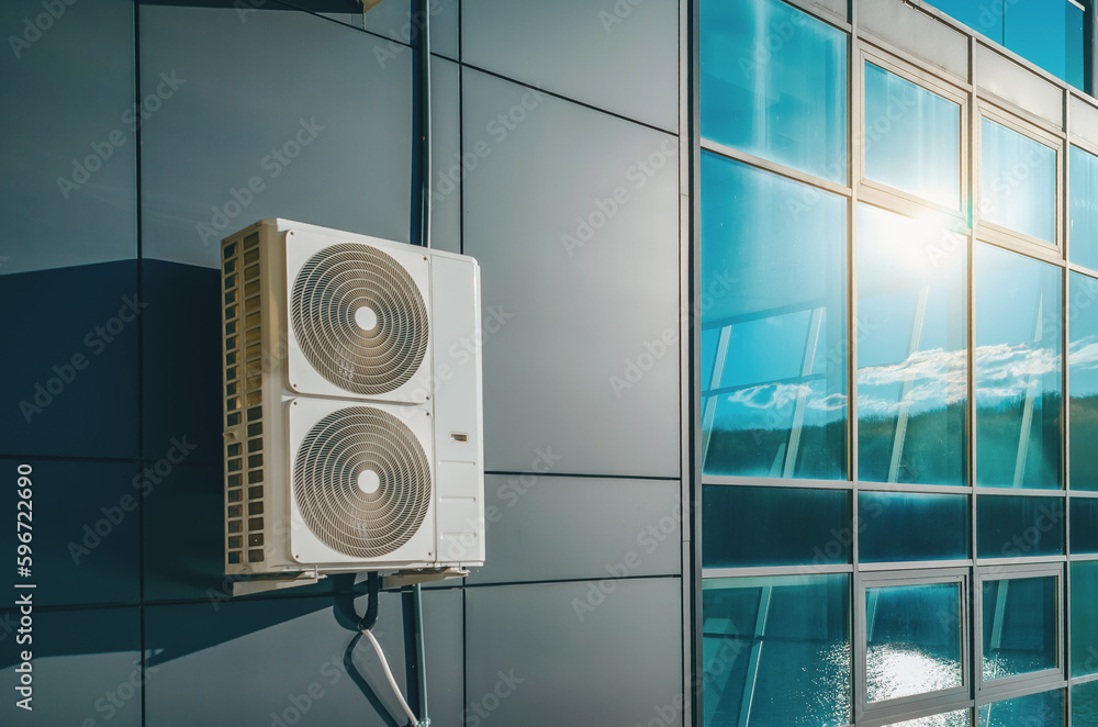 Metal wall of modern building with air conditioning unit and sun ...