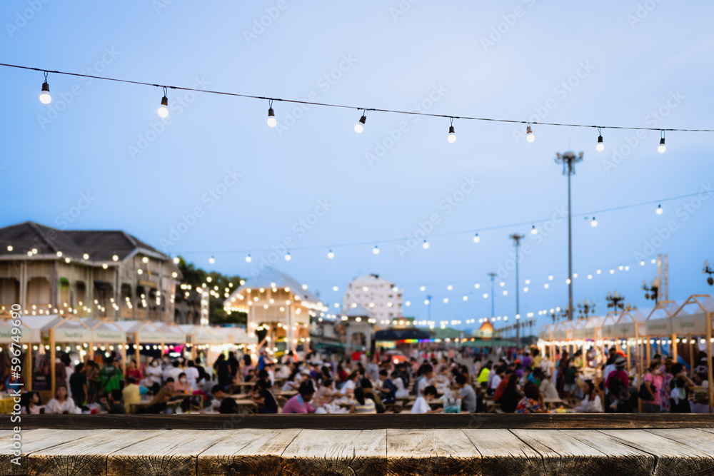 Image of wooden table in front of decorative outdoor string lights bulb ...