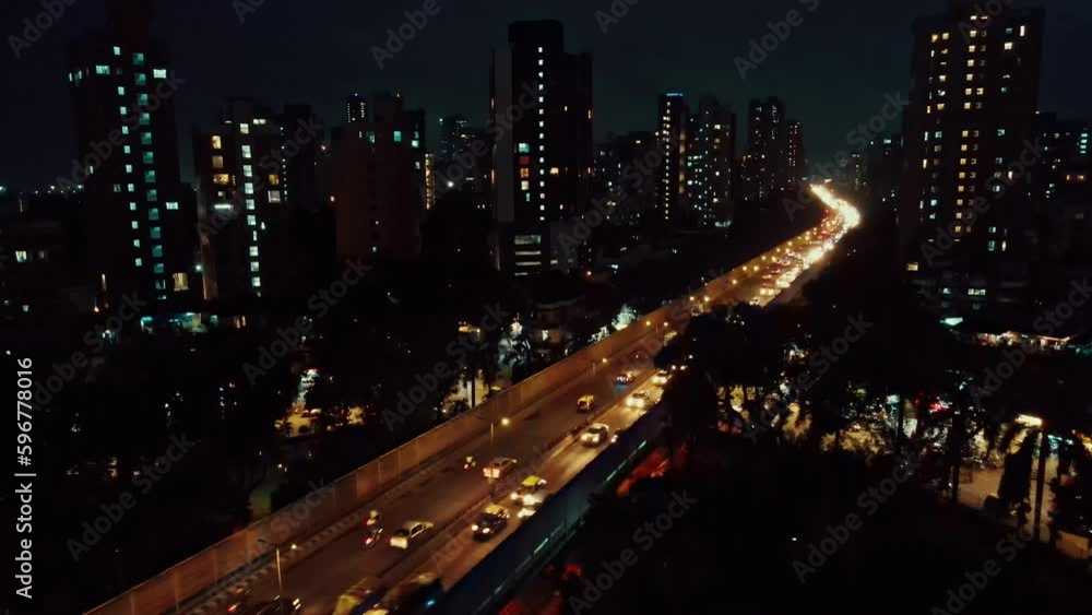 4K Aerial night footage of a busy traffic intersection illuminated with ...