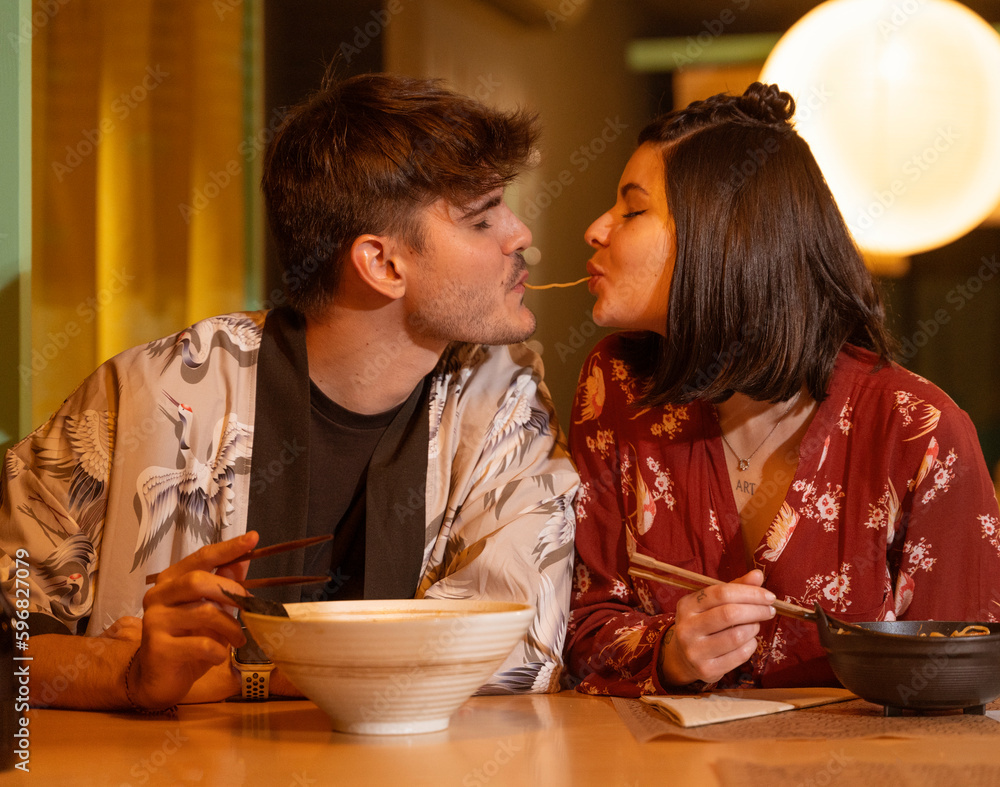 Foto de The romantic couple eat yakisoba noodles holding each other's ...