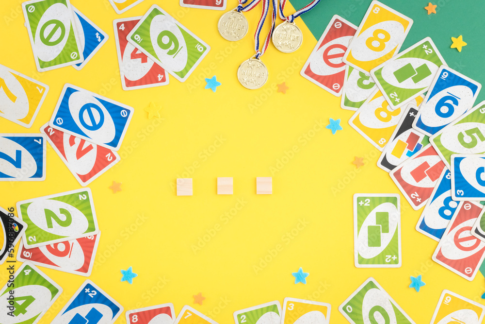 Old, dirty uno cards, winner medals, empty cubes and stars on a green ...