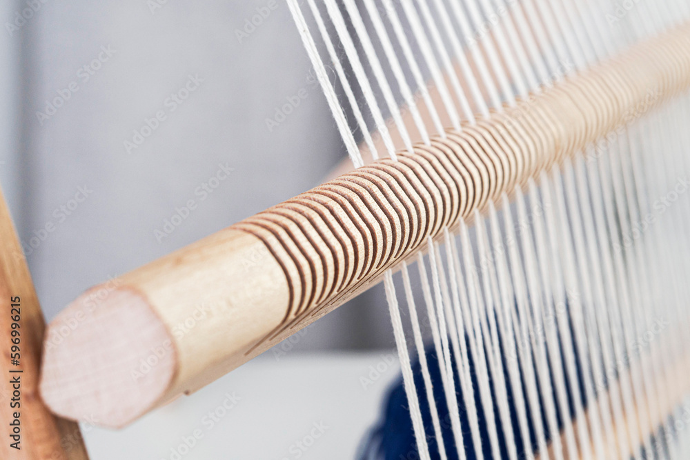 Shaft on a weaving frame. Shaft and warp thread on a weaving tool. The ...