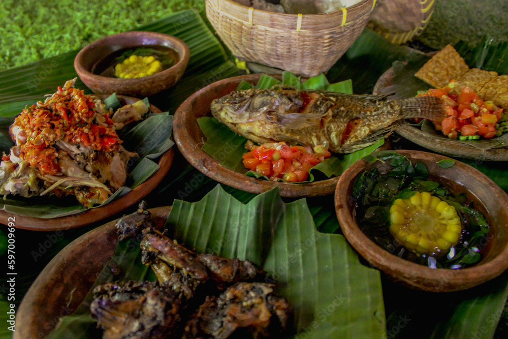 Traditional sasak dish consisting of ayam merangkat, fried tilapia ...