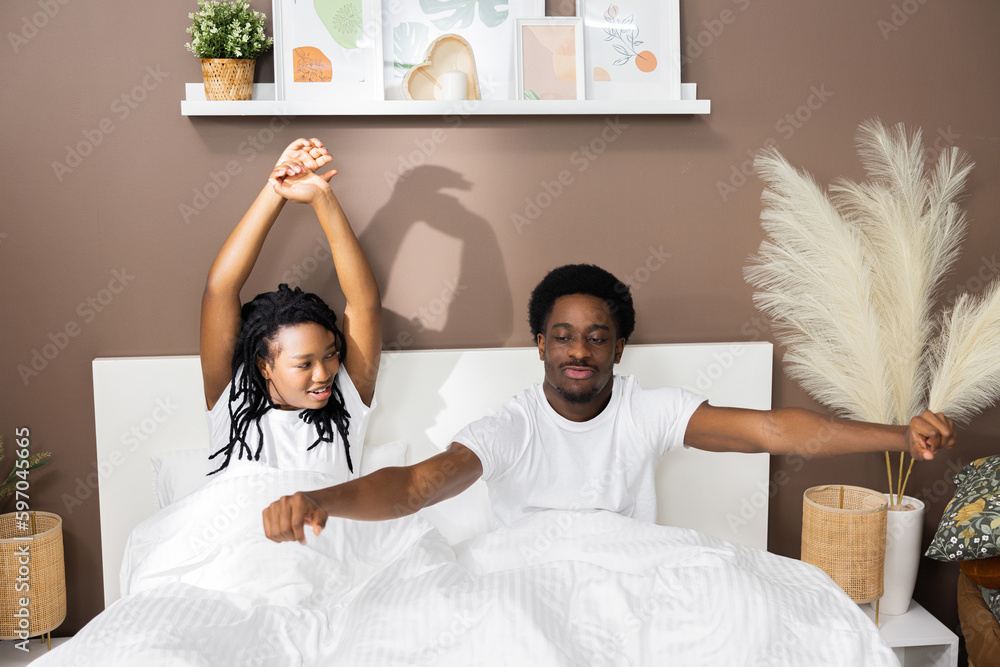 Stretching time in the morning african american man and woman awaking ...